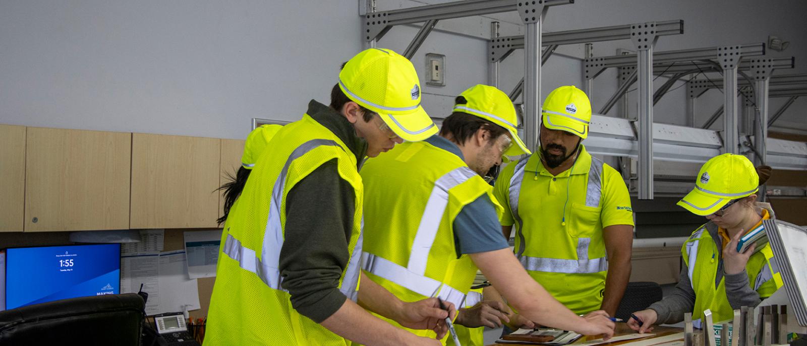 Four engineers wearing safety gear are gaining valuable experience with ...